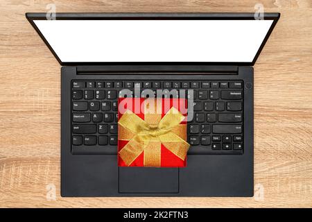 Red gift box and computer laptop on white background, top view, copy ...
