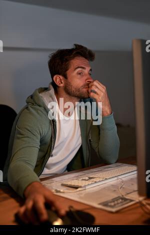 Pulling an all-nighter. a young designer working late in the office ...