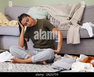 Bored, sad and woman cleaning laundry, housework stress and tired of ...