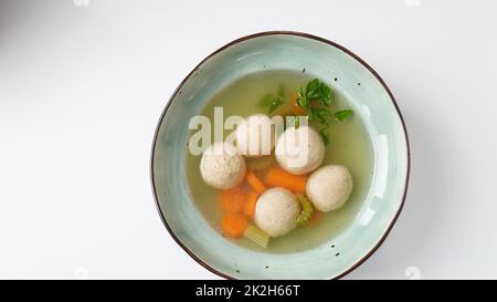 Jewish chicken broth with kneidlach (balls made with matzo meal). Matzo ...