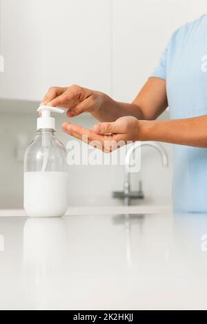 Female hands using liquid soap on light background Stock Photo - Alamy