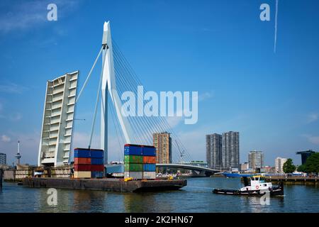 Tug boat towing barge with containers under open bascule part of ...