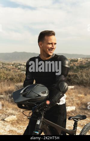 Downhill rider fully equipped with protective gear and his bicycle ...