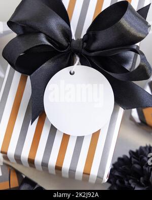 Wrapped present with a white bow and round paper gift tag on a white ...