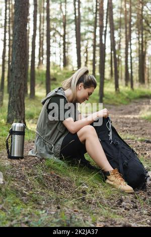 Female hiker during small halt sitting in green forest Stock Photo - Alamy