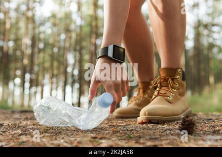 Female hiker collecting plastic waste in green forest Stock Photo - Alamy