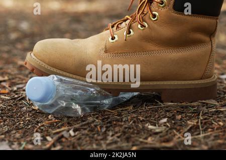 Yellow boots and plastic bottle in a forest Stock Photo - Alamy