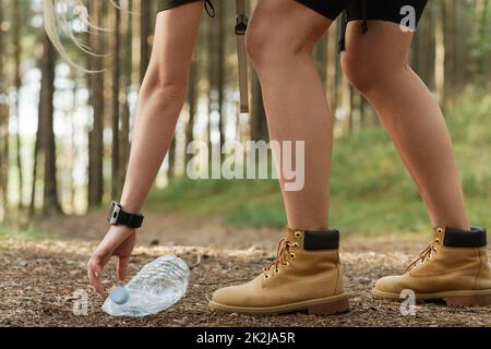 Female hiker collecting plastic waste in green forest Stock Photo - Alamy