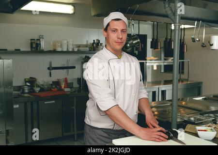 Smiling Male Chef in uniforms preparing sushi in a kitchen of asian ...