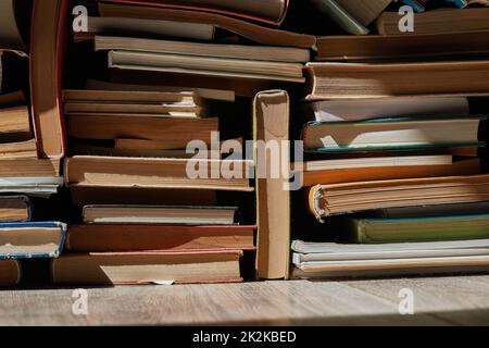 Wall of books piled up Stock Photo - Alamy