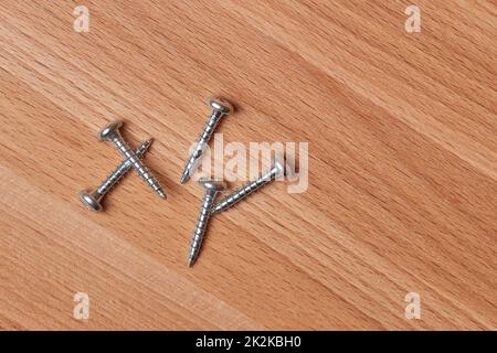 screws on a wooden table Stock Photo - Alamy