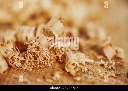 Heap of fresh sawdust and wood shavings on a workbench in a woodworking ...