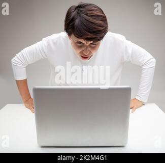 An angry businesswoman staring at her laptop Stock Photo - Alamy