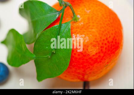 tangerine and blueberry on white table Stock Photo - Alamy