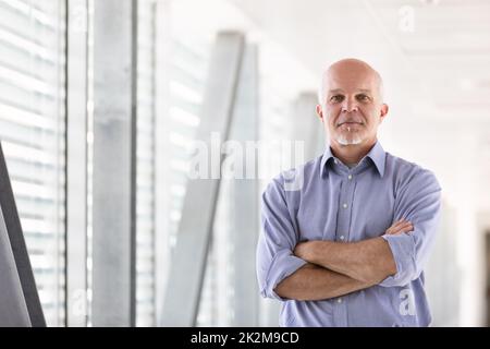 Business man facing the camera with arms crossed Stock Photo - Alamy