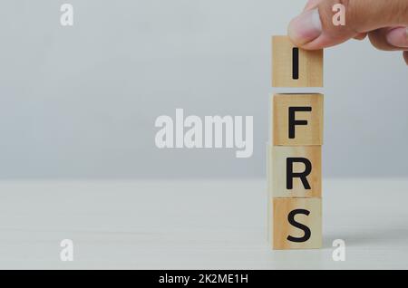 Hand put wooden cubes IFRS International Financial Reporting Standards ...