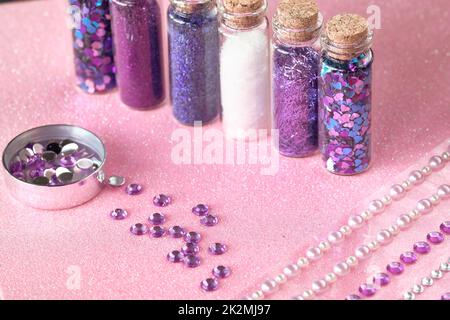 All kinds of glitter products on pink sparkling background. Close-up on ...
