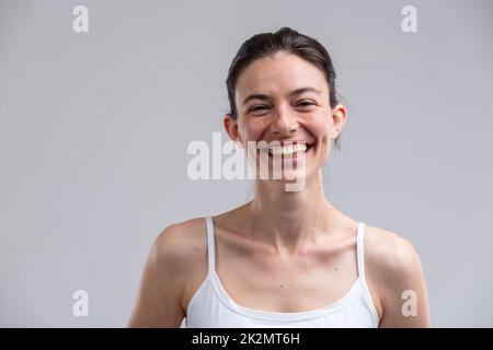 Cute charismatic young woman with a cheeky vivacious grin in a head and ...