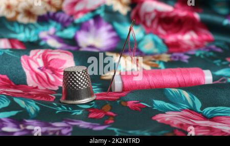 Thimble With Needle and Pink Thread on Vintage Floral Satin Fabric ...