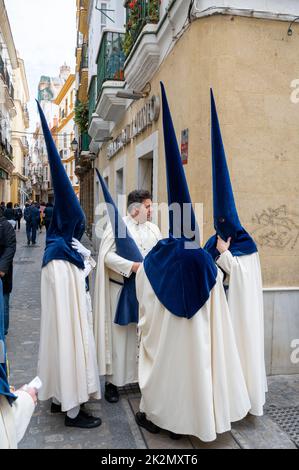 People wearing traditional capirote conical pointed hats in an easter ...