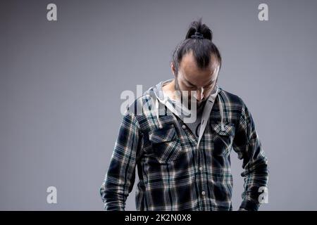 Depressed unmotivated man staring down at the floor with a dejected ...