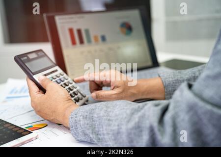 Asian accountant working and analyzing financial reports project ...