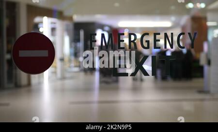 Emergency exit sign on empty city mall during pandemic Stock Photo - Alamy