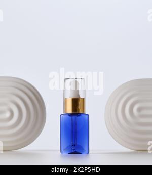 blue glass bottle with pipette for cosmetics, oils and serum ...