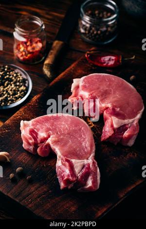 Two pork loin steaks with knife on rustic cutting board Stock Photo - Alamy