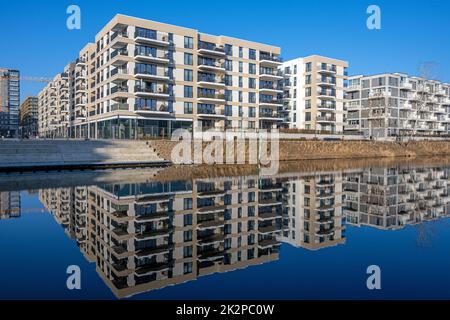 Modern residential buildings with a perfect reflection in a small canal ...