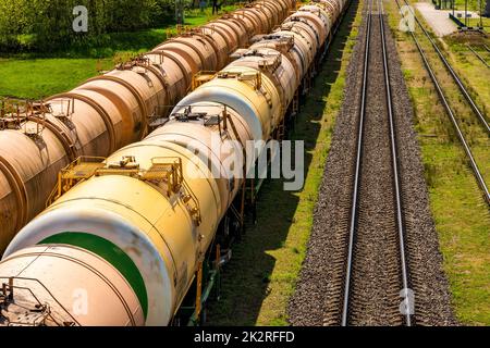 Cargo trains transporting liquid fuel at depot. Set of tanks with oil ...