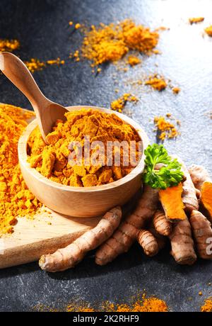 Composition with bowl of turmeric powder Stock Photo - Alamy