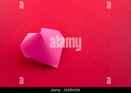Pink paper heart origami isolated on a blank grey background ...
