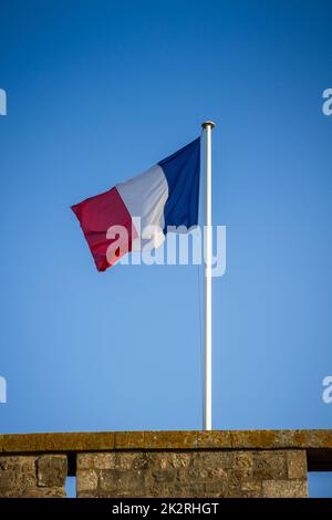 French flag on a pole floating in the wind. Blue sky background Stock ...