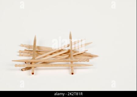 Pile of round wooden toothpicks and toothpick box with a plastic cover ...