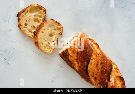 Sliced freshly baked French baguette with appetizing crispy crust on ...