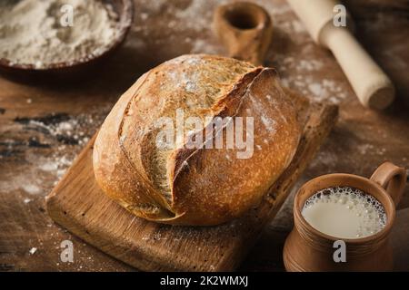 Crunchy freshly baked loaf of bread on the kitchen table Stock Photo ...