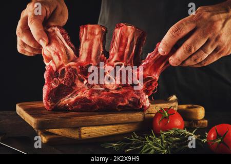 Male butcher cuts raw beef meat Stock Photo - Alamy