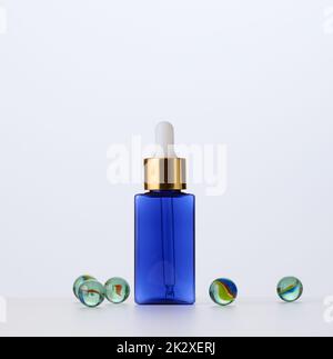 blue glass bottle with pipette for cosmetics, oils and serum ...