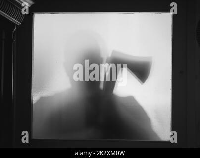 Man killer with an axe in his hand. Creepy background Stock Photo - Alamy