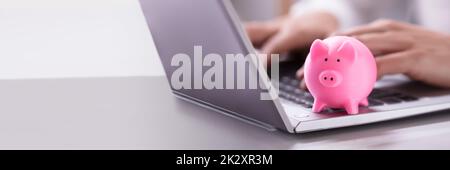 a pink piggy bank on a laptop Stock Photo - Alamy