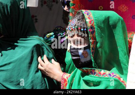 People in traditional Pashtun dresses pose for photos during a ceremony ...