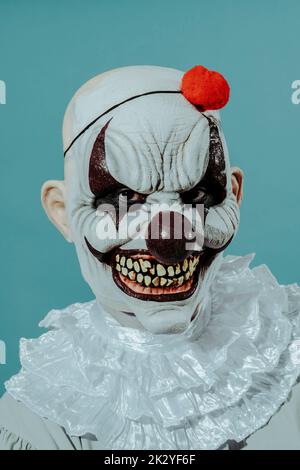 Scary halloween clown with menacing smile holding sack dark room with ...