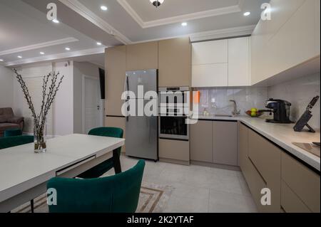 Modern white and beige large luxurious kitchen and dining table in ...