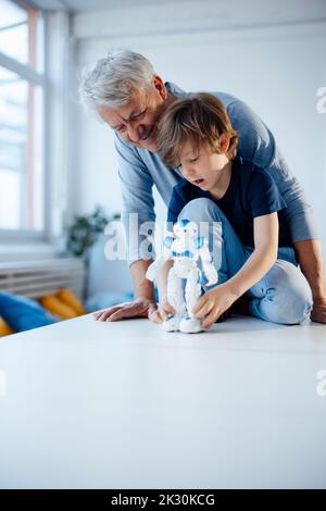 Boy with robot model by grandfather at home Stock Photo - Alamy