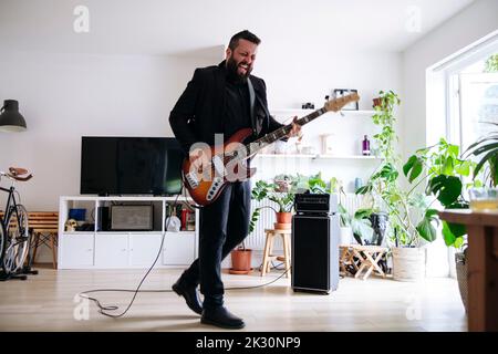 Businessman playing guitar at home Stock Photo - Alamy