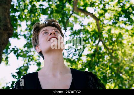 Portrait of happy non-binary person standing with transgender symbol on ...