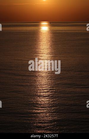 The golden early morning sun moments after sunrise catches the statue ...