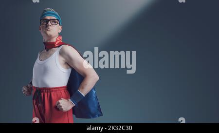Funny superhero with glasses and small cape, he is posing and looking ...