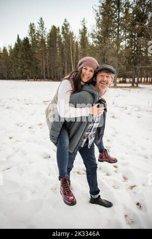 Man giving wife a piggyback Stock Photo - Alamy